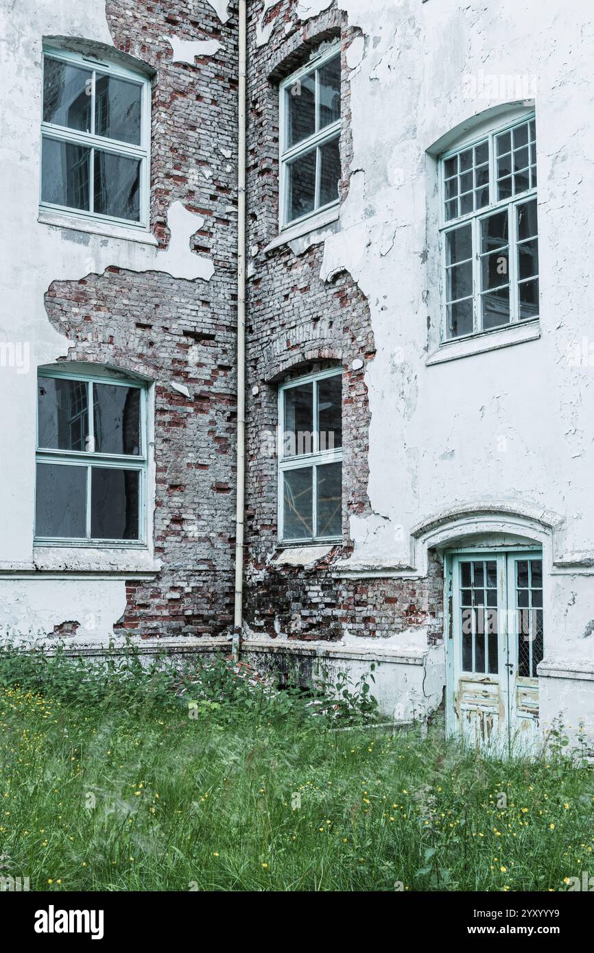 Decaying walls of an old sanatorium show signs of neglect as nature reclaims the grounds ...