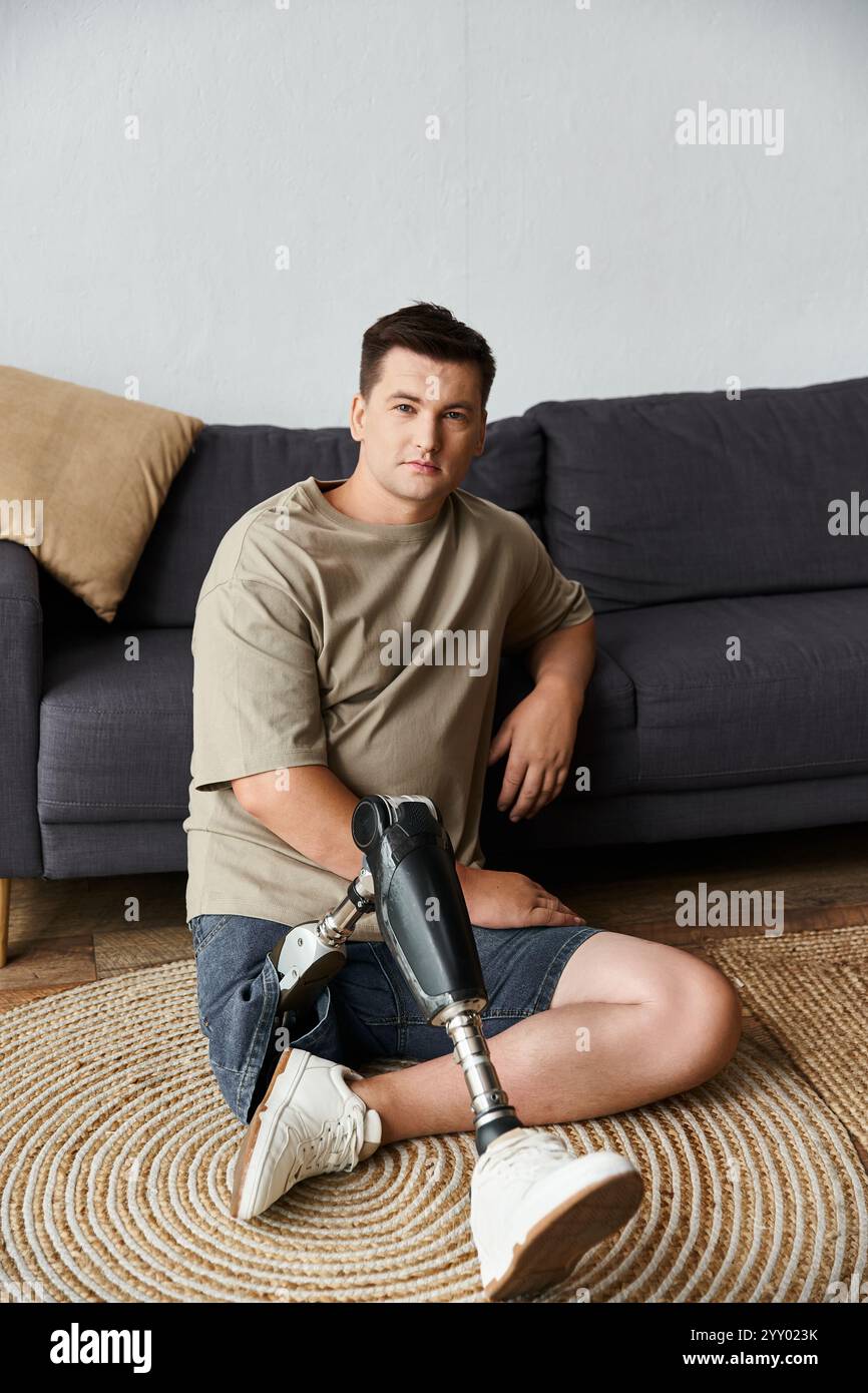 Handsome young man relaxed on floor with a prosthetic leg, enjoying the ...