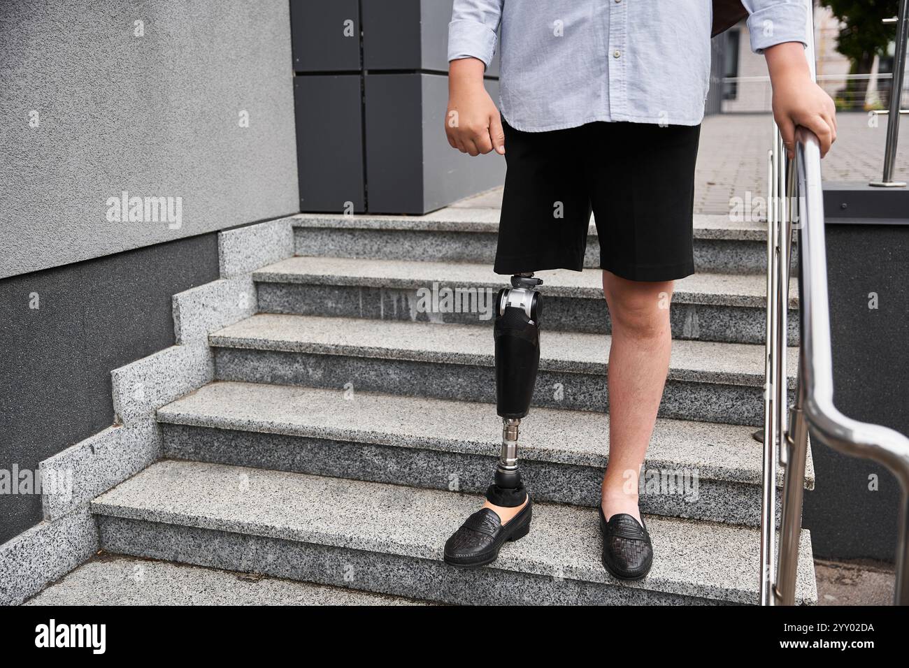 A young handsome man confidently walks down stone steps with a ...