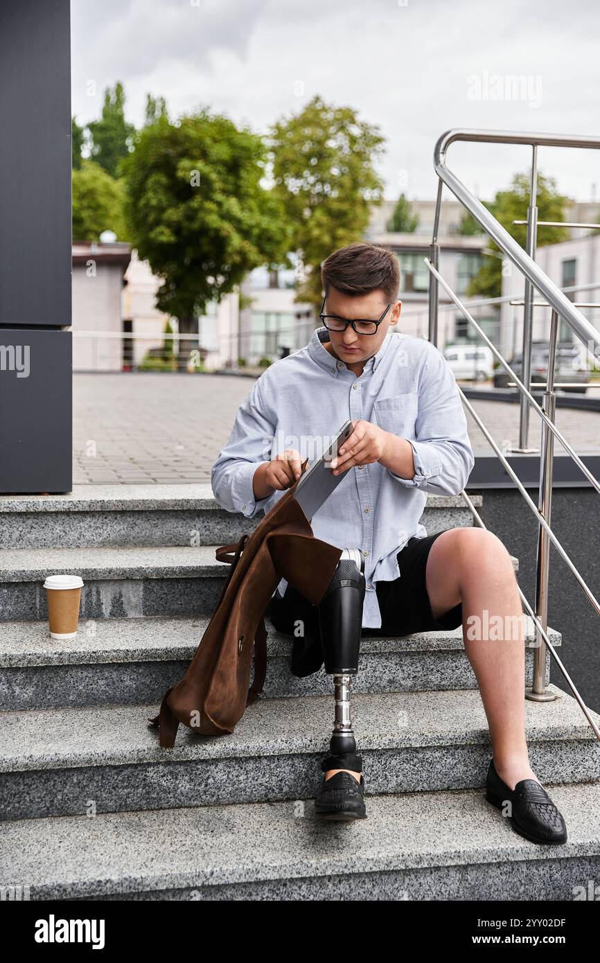 Handsome young man with prosthetic leg fine tuning his leg on outdoor ...