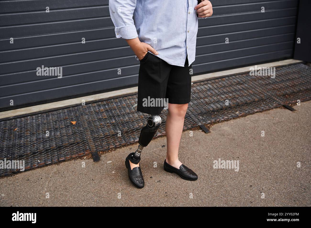 Young man stands proudly with his hands in his pockets, showcasing his ...