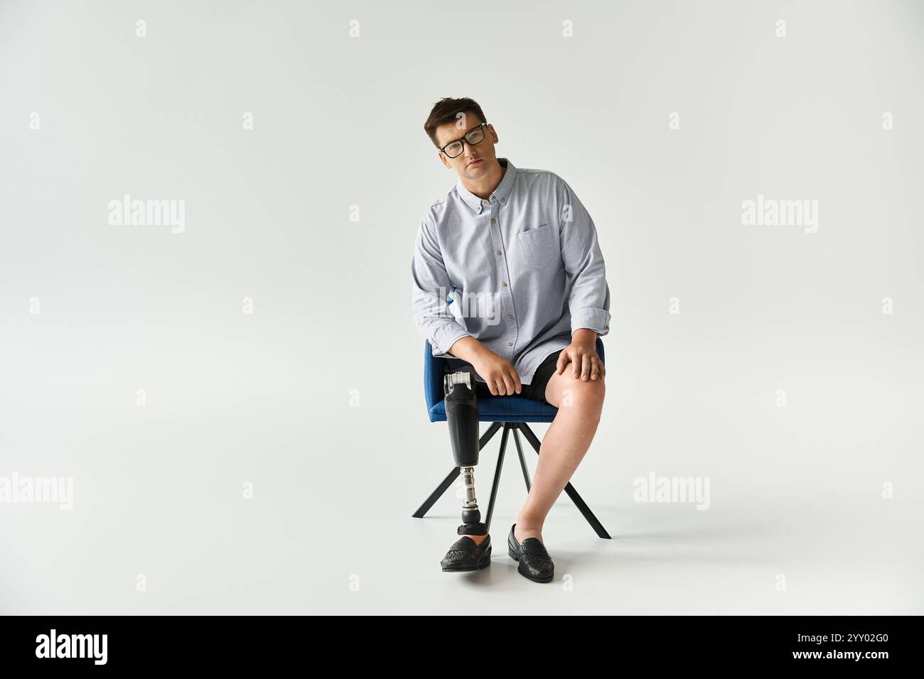 Young man with a prosthetic leg poses in a modern setting, showcasing ...