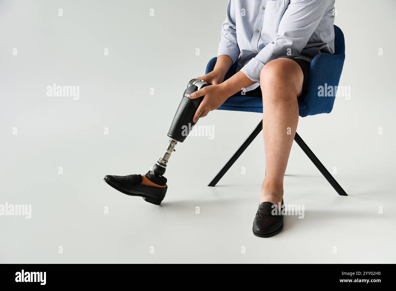 Young man sits comfortably, adjusting his prosthetic leg and showcasing ...