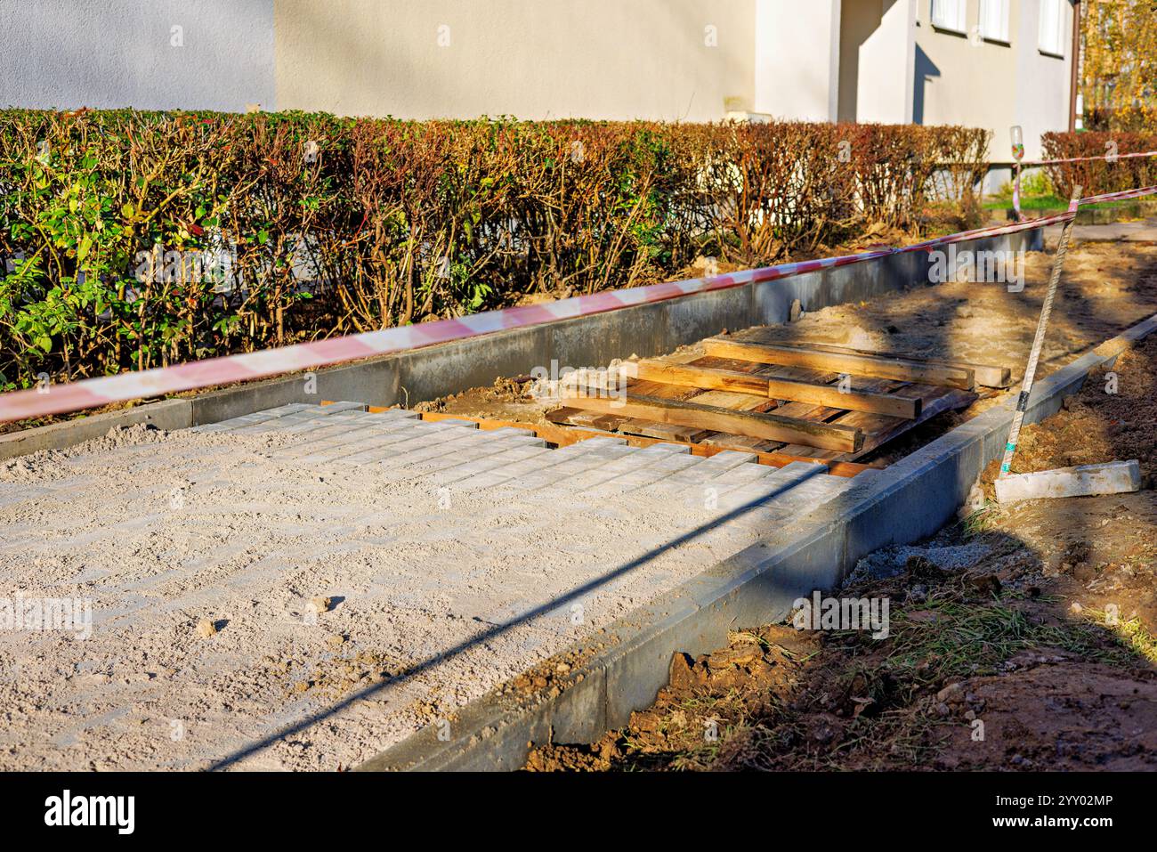 A new pedestrian path, half lined with paving slabs Stock Photo - Alamy