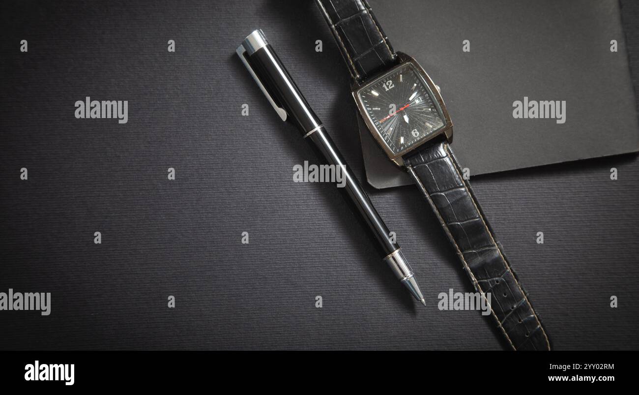 Black pen, wristwatch, notepad on the black background Stock Photo - Alamy