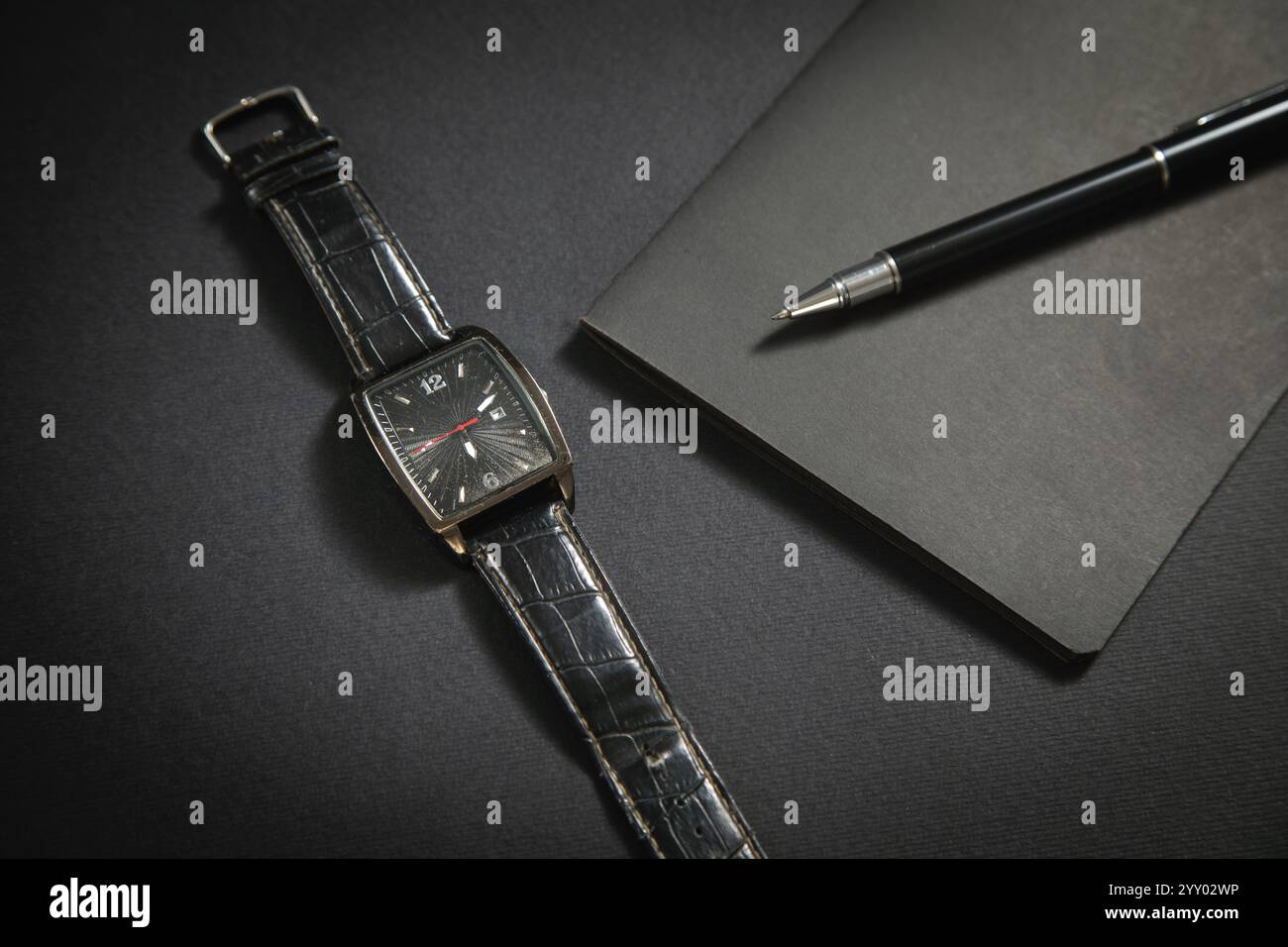 Black pen, wristwatch, notepad on the black background Stock Photo - Alamy
