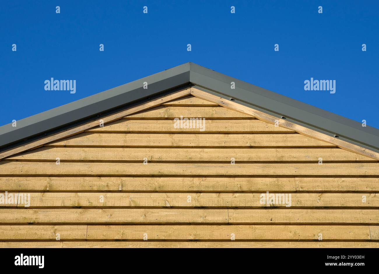 timber clad roof line apex on blue sky background Stock Photo - Alamy