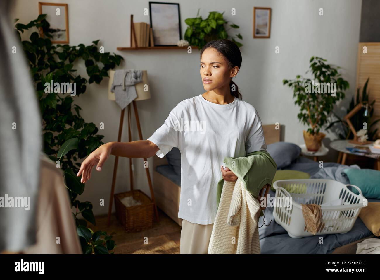 A young African American woman is busy organizing her stylish apartment ...