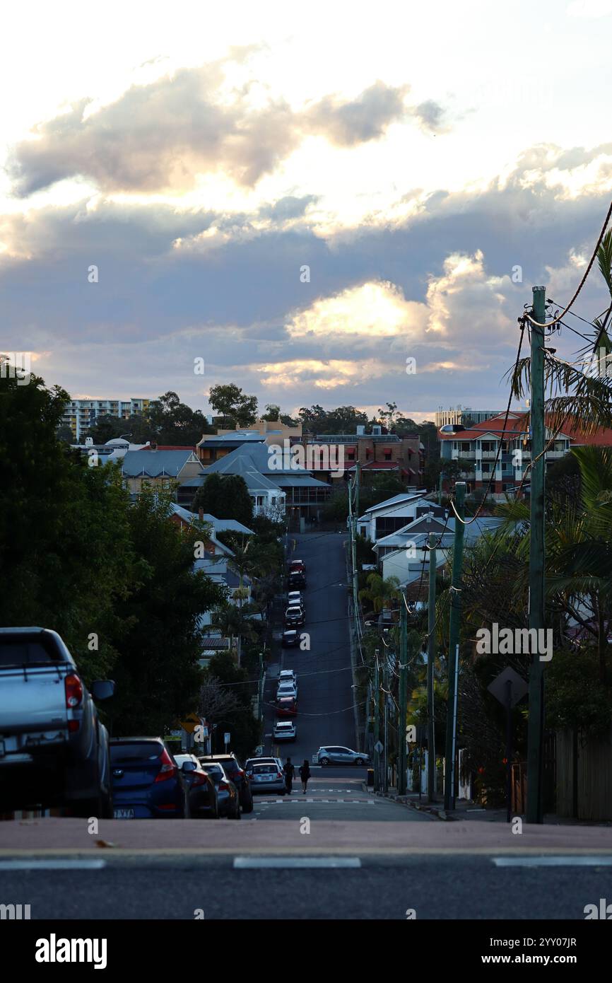 A view of the steep street at sunset in Brisbane, Australia. Cars ...