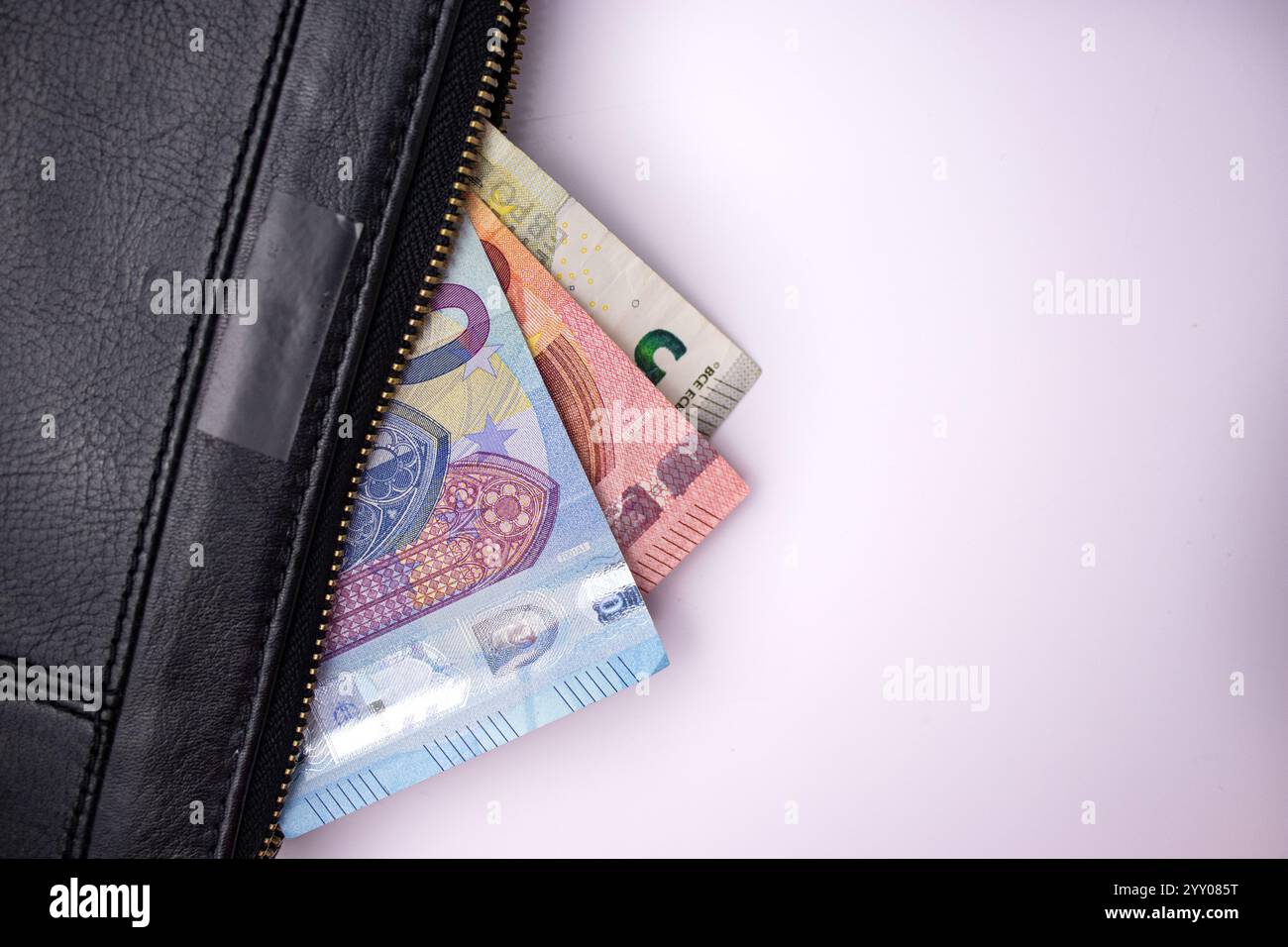 Black leather wallet with five, ten and twenty euro bills banknotes on ...