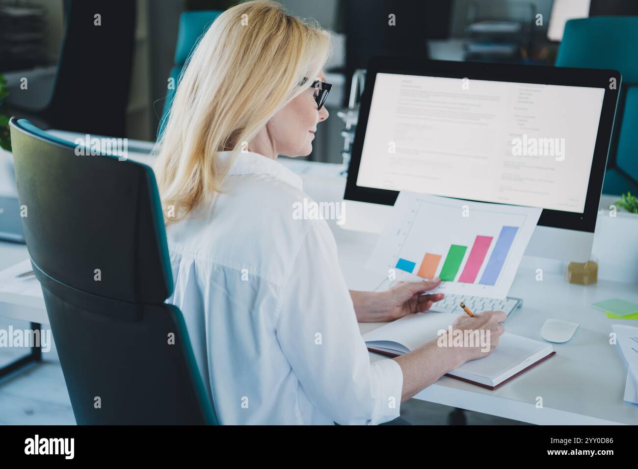 Photo of data analytic blonde lady working with information holding diagrams wearing formal ...