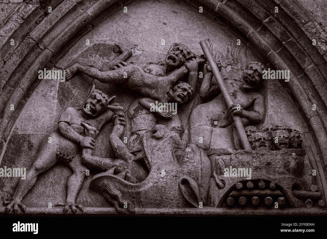 Horned demon grips the ankles of a sinner and thrusts him into the wide ...