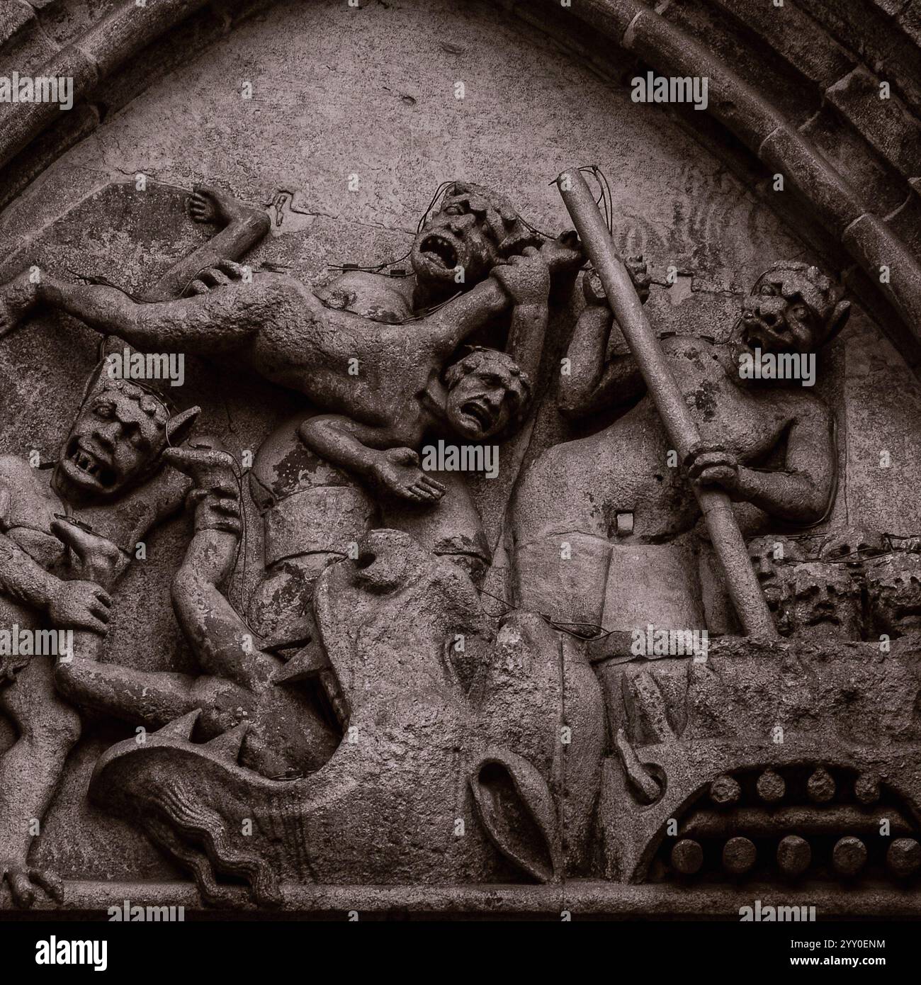 Horned demon grips the ankles of a sinner and thrusts him into the wide ...