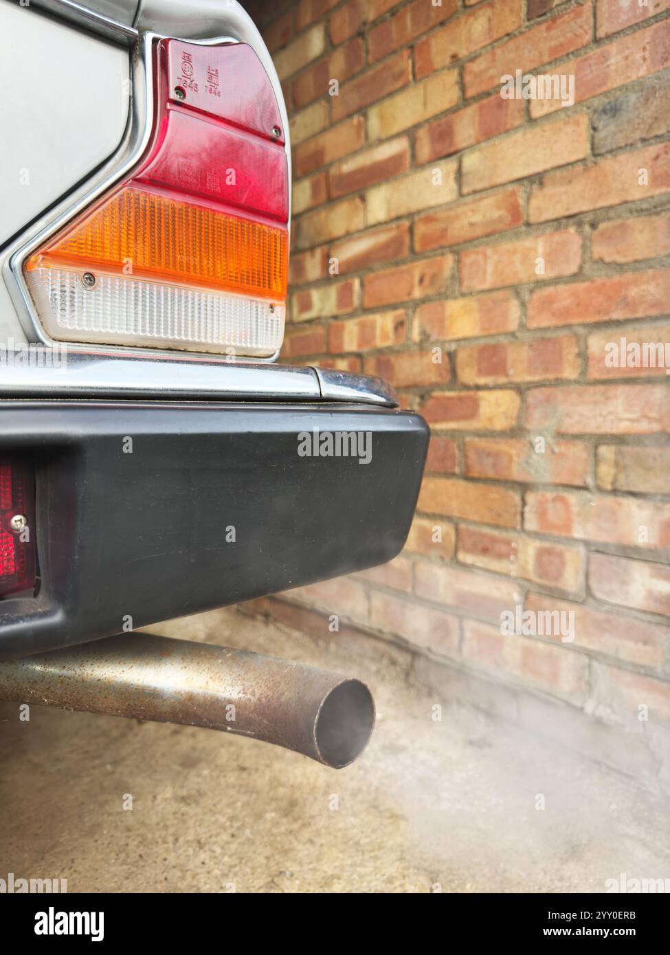 Closeup of fumes from the rear exhaust tail pipe of an old petrol ...