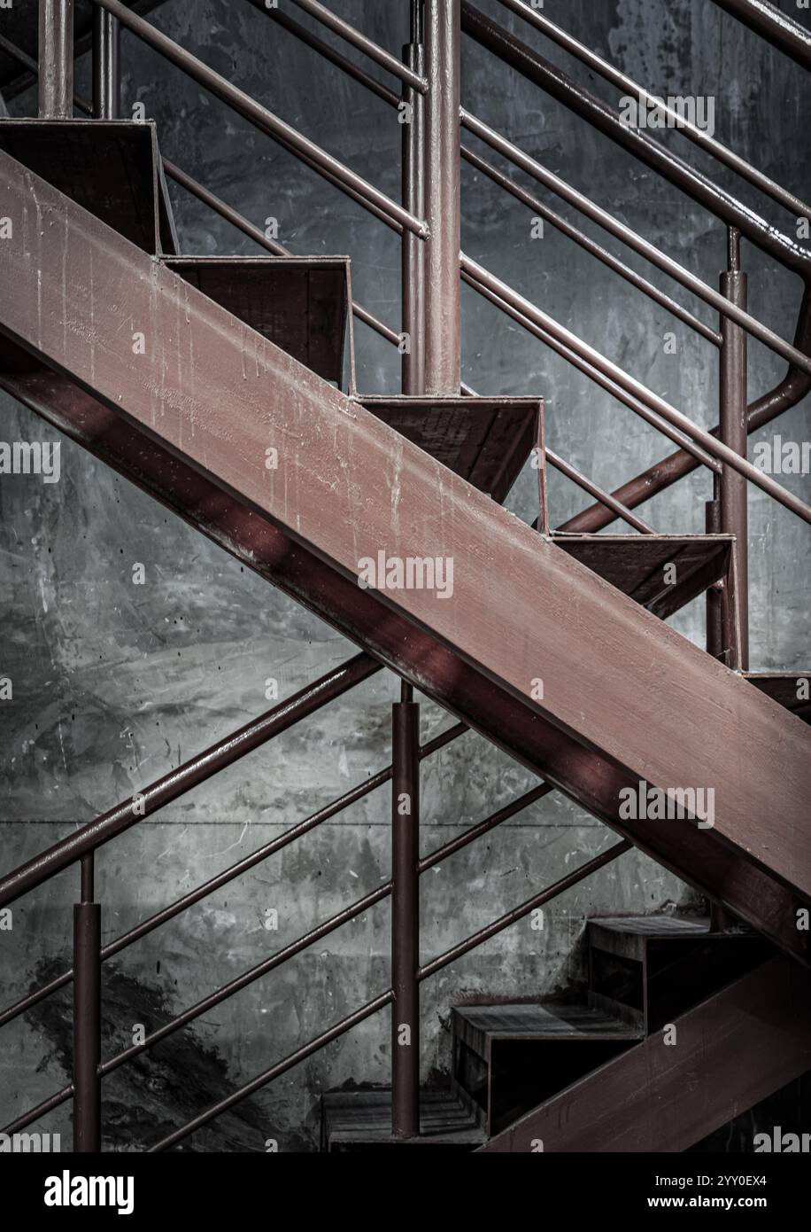 Vertical view of Old Steel ladder with handrails with concrete wall in ...