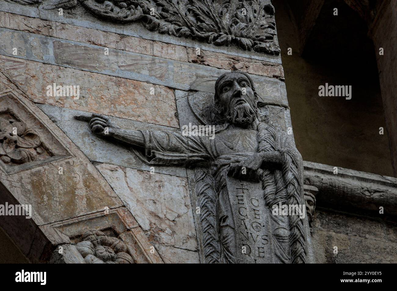 Medieval statue of grim finger-pointing man who displays a scroll with ...