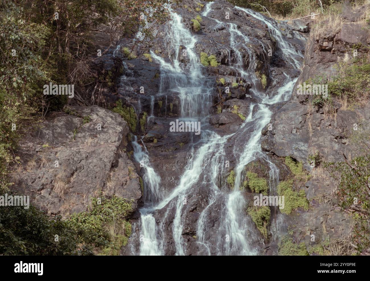 Waterfall stream falling down rocks and stones of mountain steep slope ...