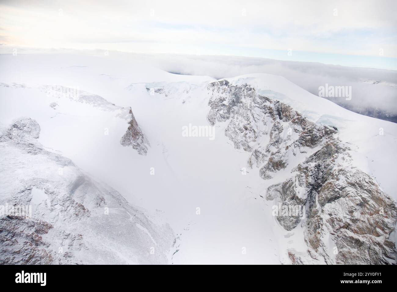 A helicopter view of the snowy mountains and fjords of Greenland in ...