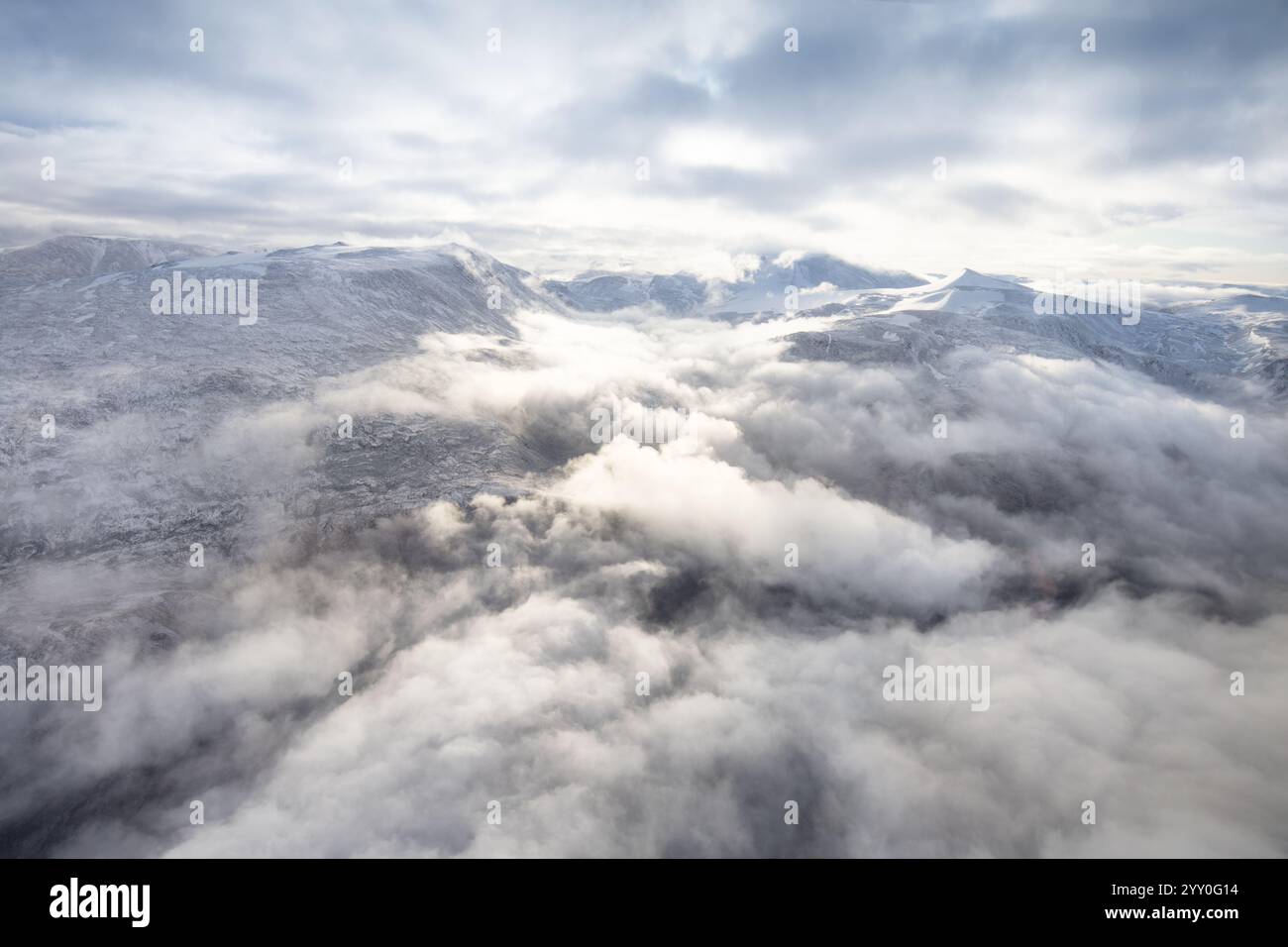 A helicopter view of the snowy mountains and fjords of Greenland in ...