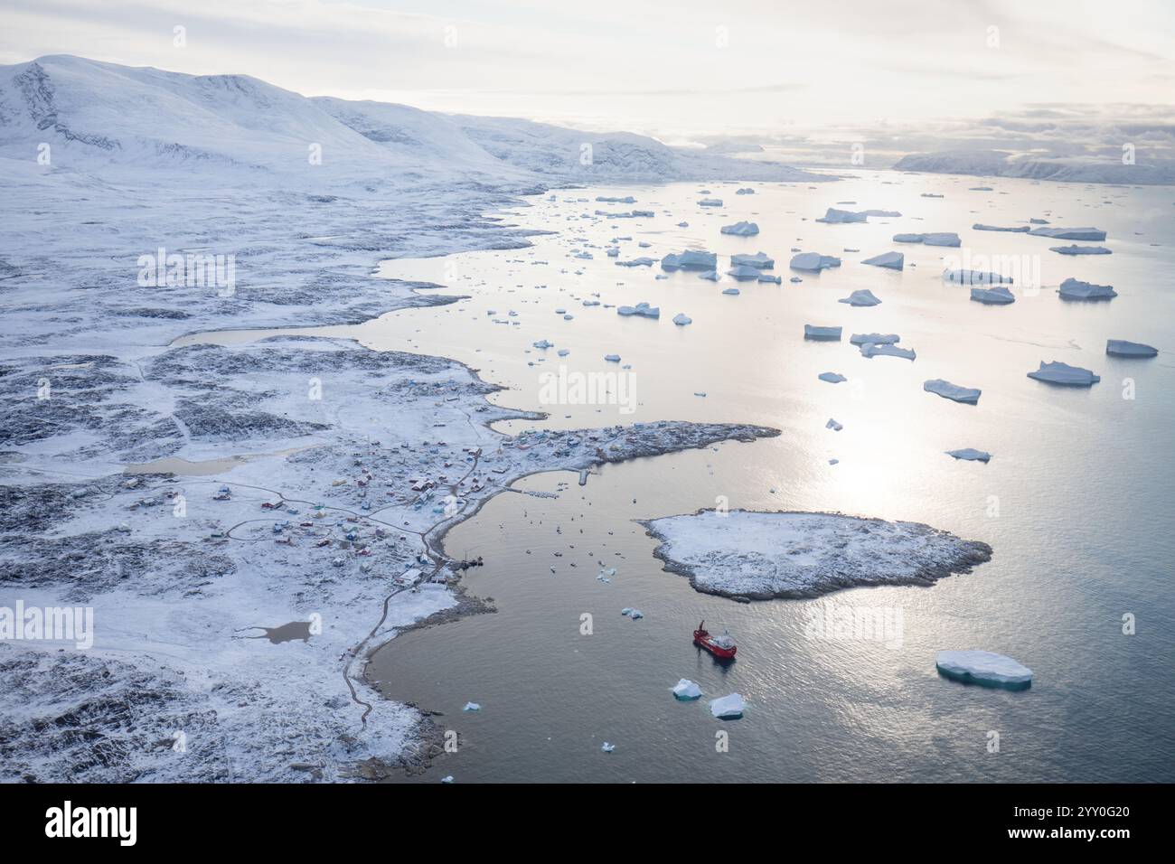 A helicopter view of the snowy mountains and fjords of Greenland in ...