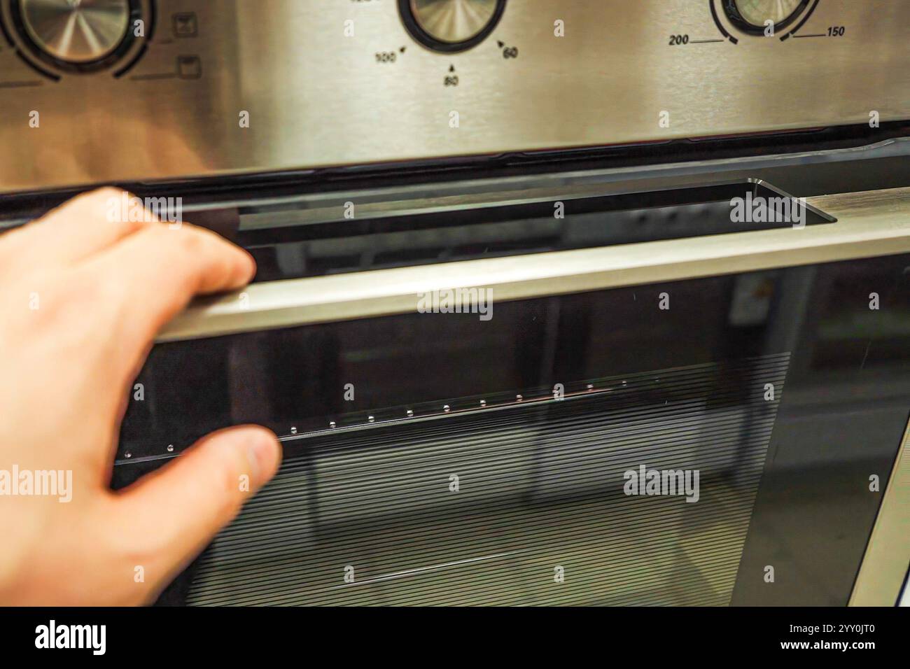 Hand opening a modern oven in a kitchen store Stock Photo - Alamy