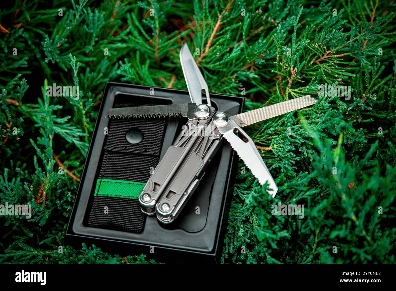 Multitool pocket knife in open case on greenery Stock Photo - Alamy