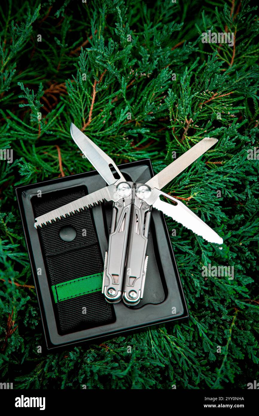 Multitool pocket knife in open case on greenery Stock Photo - Alamy