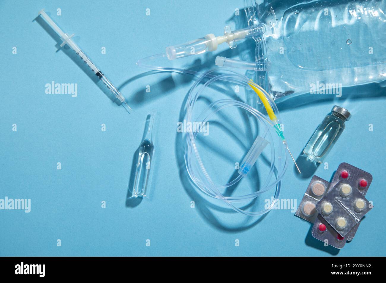 Infusion bag, syringe, medical ampoules in the blue background. IV drip ...