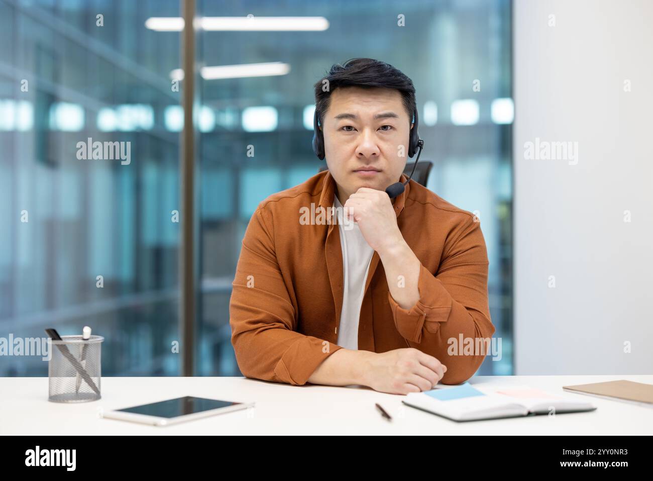 Asian man mature businessman sitting at a desk and wearing a ...