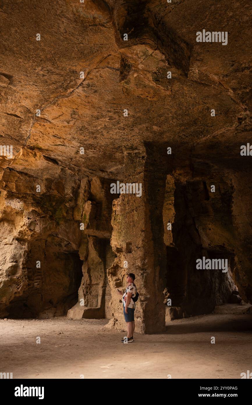 Huge tomb of the Kings in Paphos and small anonymous man he stands with ...