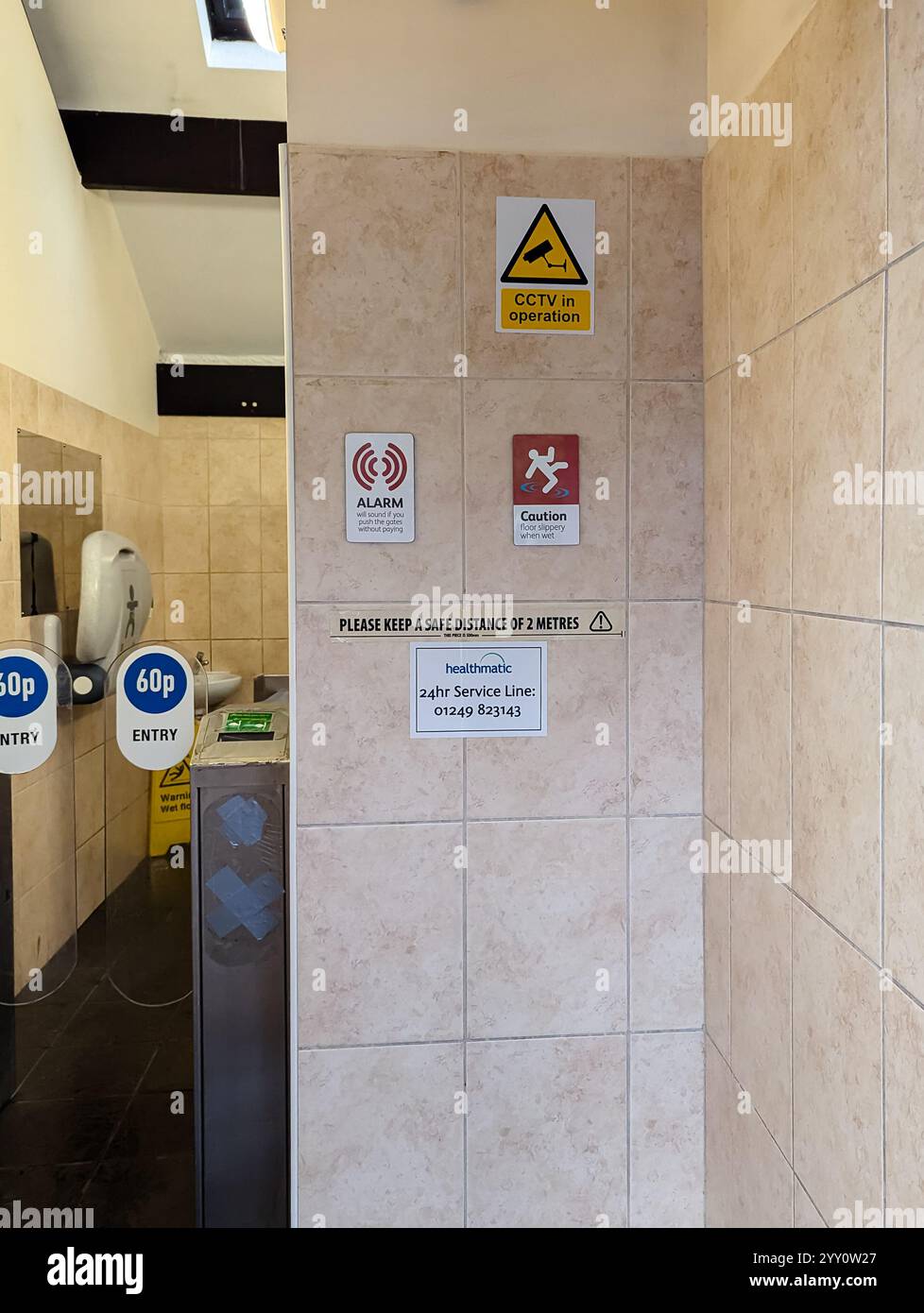Public restroom with various signs and symbols indicating the presence ...