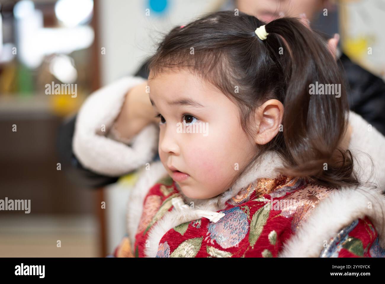 The young Chinese mother is combing her daughter's hair. Her daughter ... The young Chinese mother is combing her daughter's hair. Her daughter ...