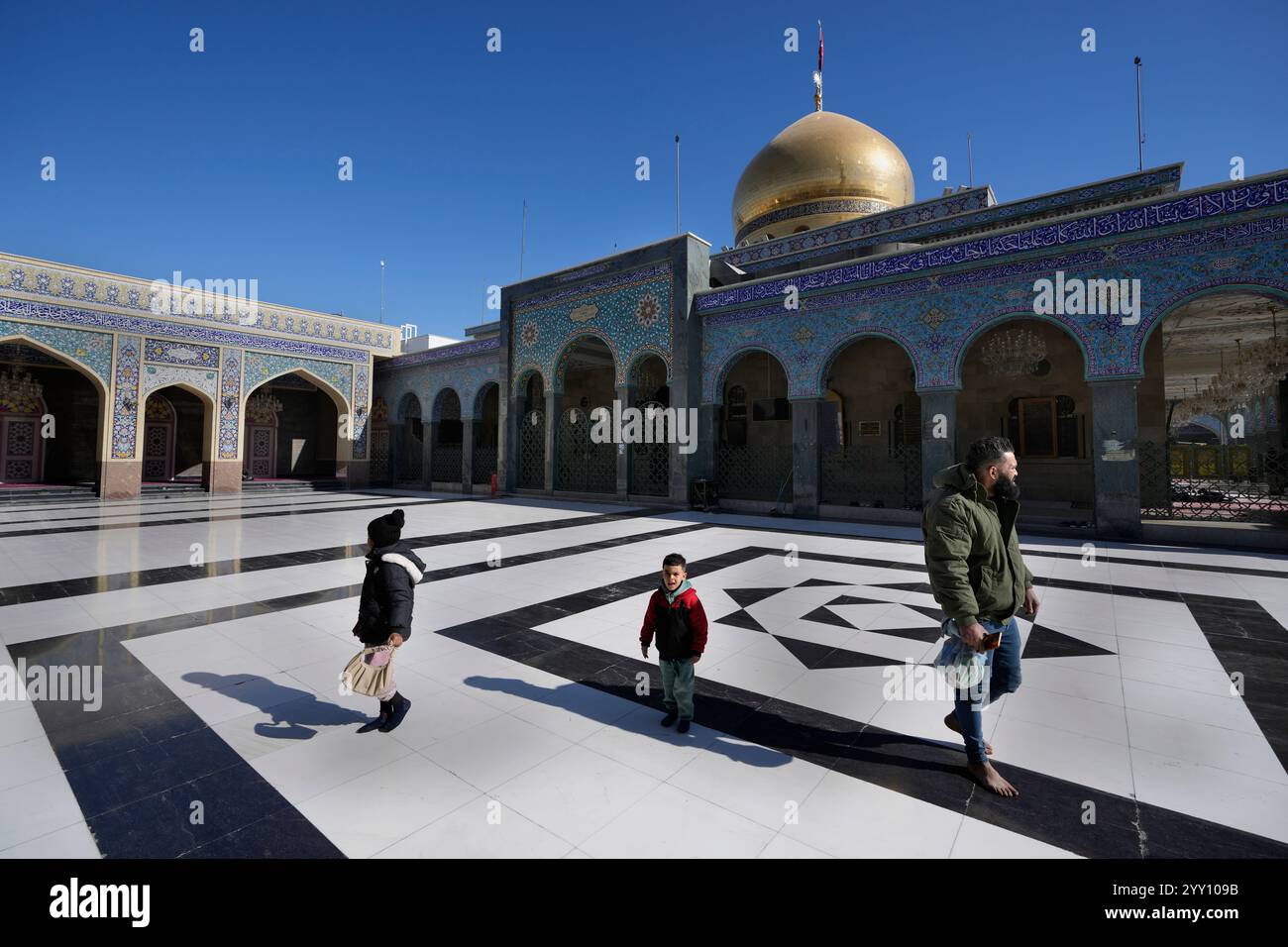 A Syrian man walk with his children at the shrine of al-Sayydah Zeinab ...
