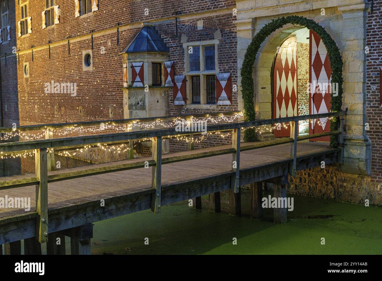 Cosy bridge with fairy lights leads to the decorated entrance gate of a ...