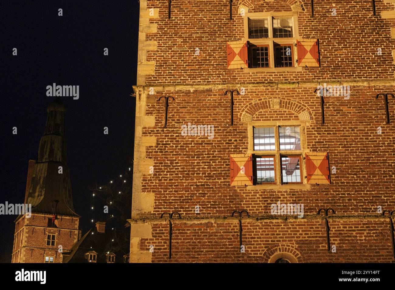 Detail of a castle tower at night with illuminated windows and clear ...