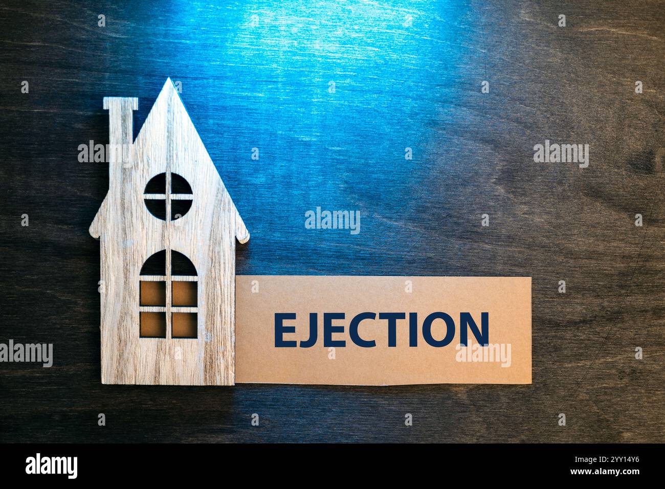 wooden cut out house representation on a wooden table with a card ...