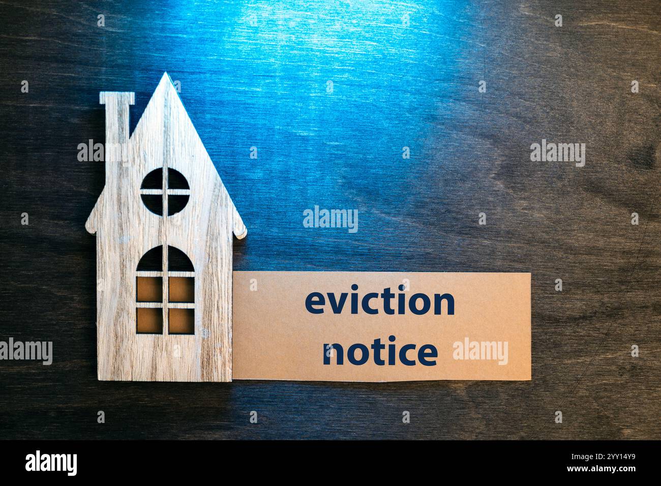 wooden cut out house representation on a wooden table with a card ...