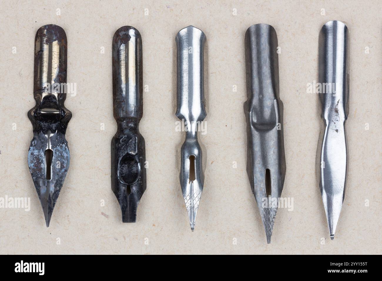 Metal nibs on an antique textured paper background Stock Photo - Alamy