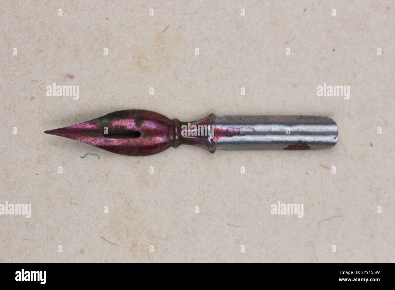 Metal nib on an antique textured paper background Stock Photo - Alamy