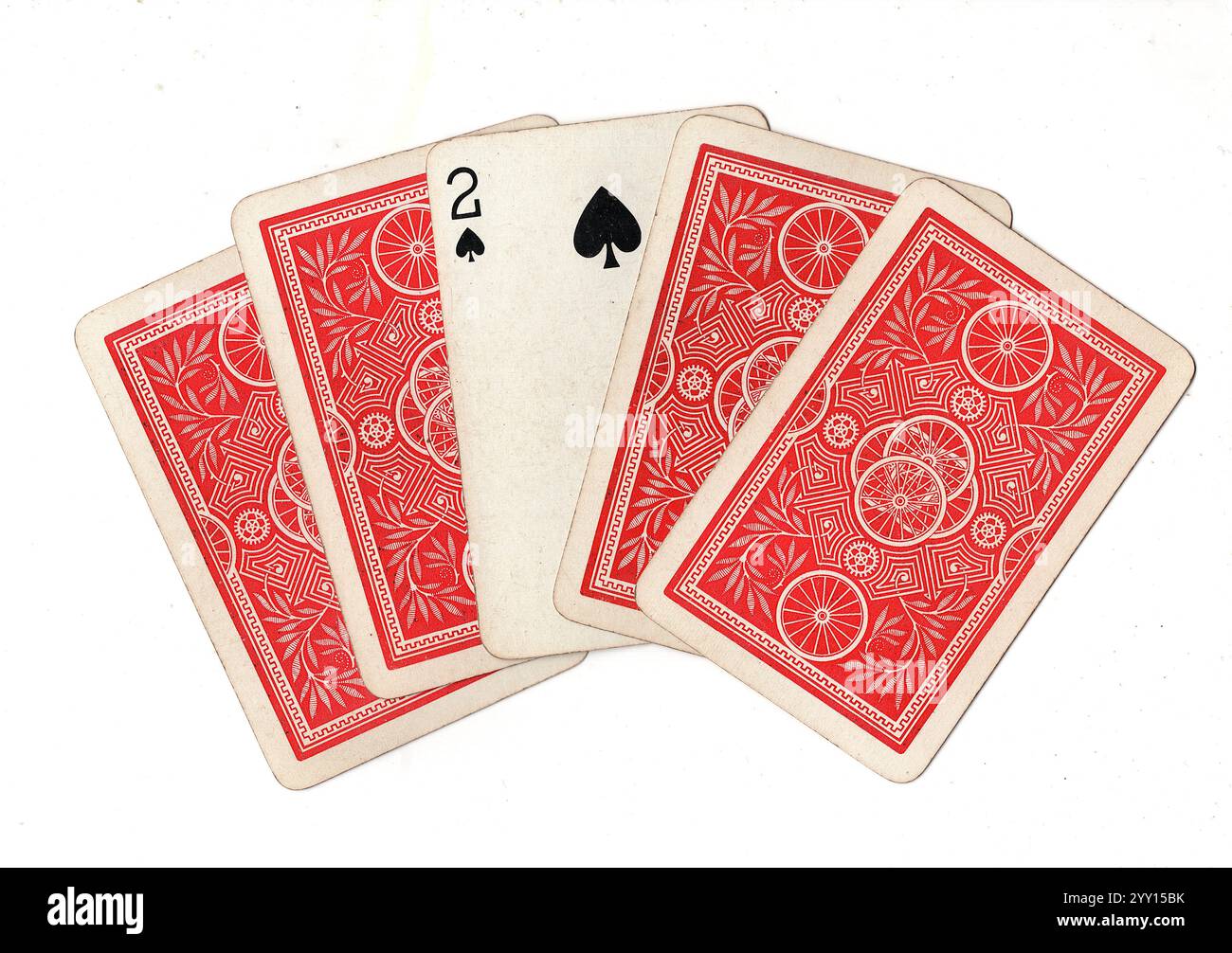 A hand of vintage playing card backs with the two of spades revealed on ...