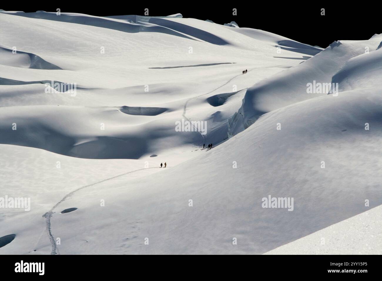 Group of climbers traversing the snow-covered slopes of Huayna Potosí ...