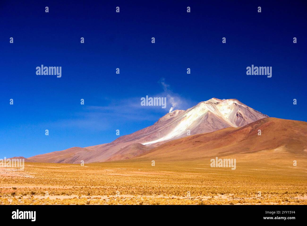 Stunning volcano in Bolivia, with a clear blue sky. The volcano emits a ...