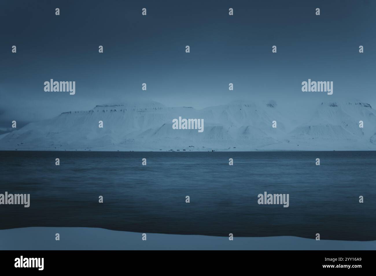 Snowy mountains in the polar night across the fjord in Longyearbyen ...