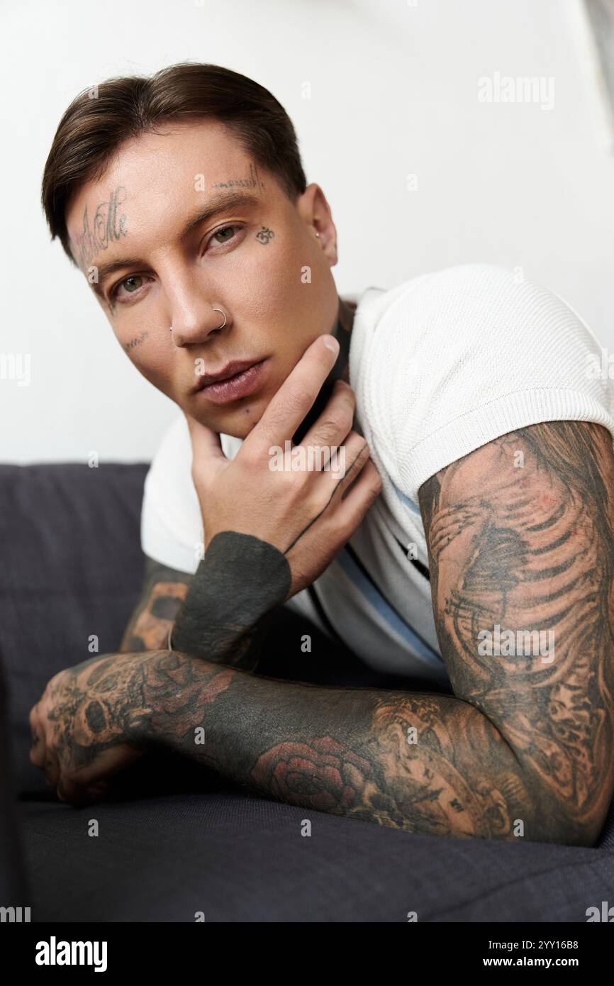 A handsome young man rests his chin on his hand, showcasing detailed ...