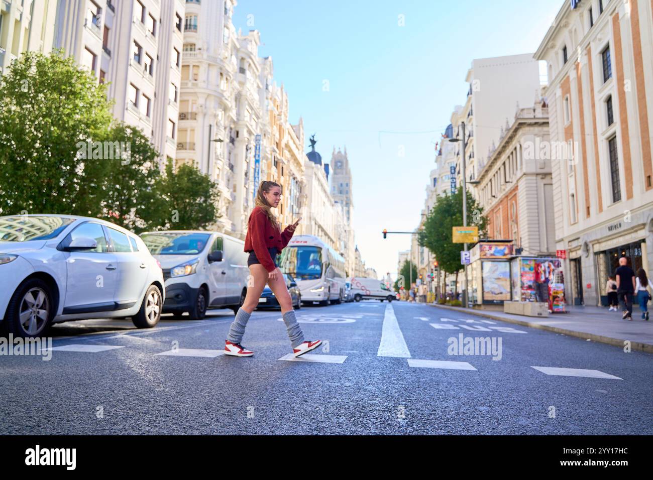 Portrait of a young Caucasian woman holding her mobile phone as she ...