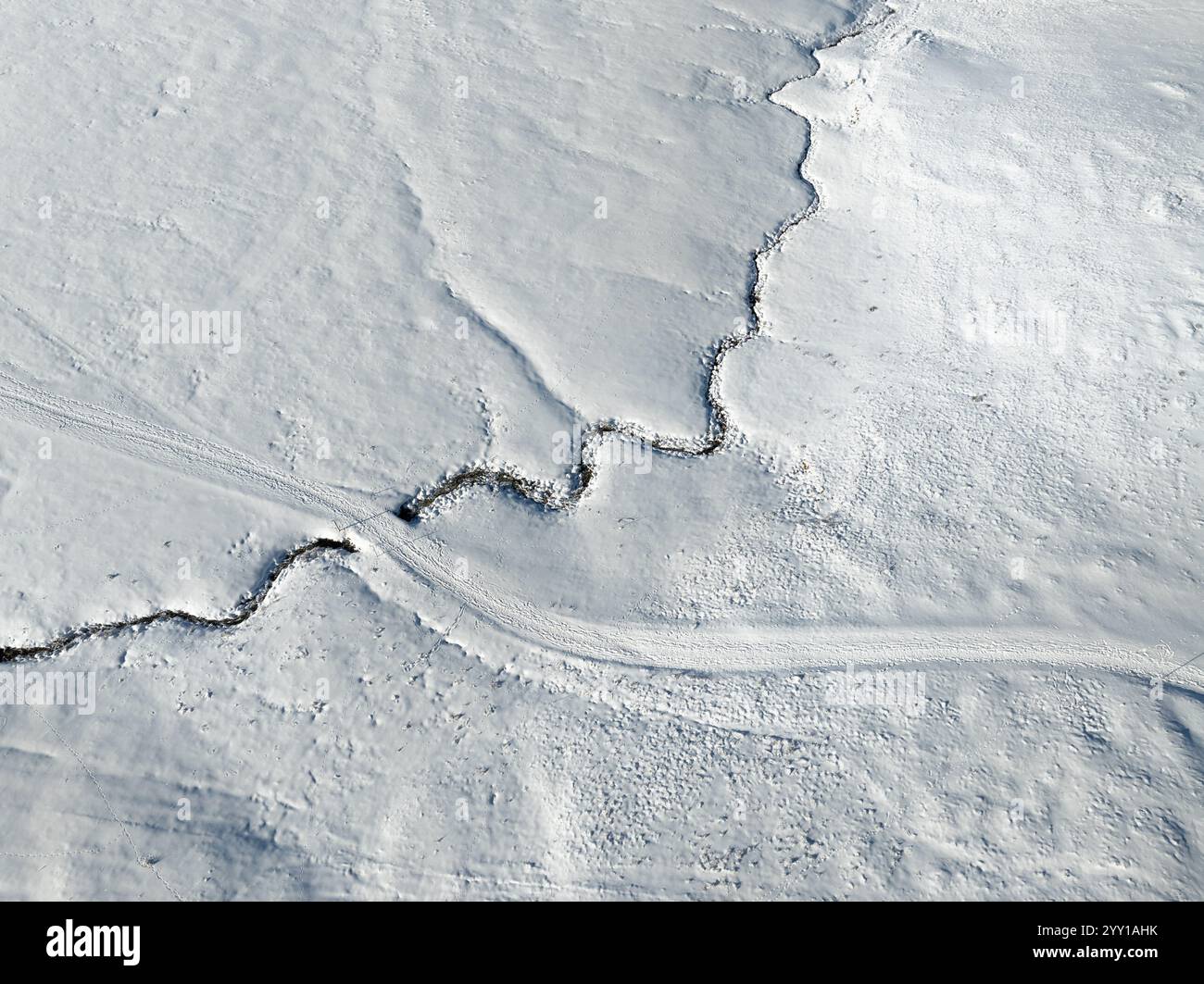 aerial photo of a little creek winding in the snowy landscape of the ...