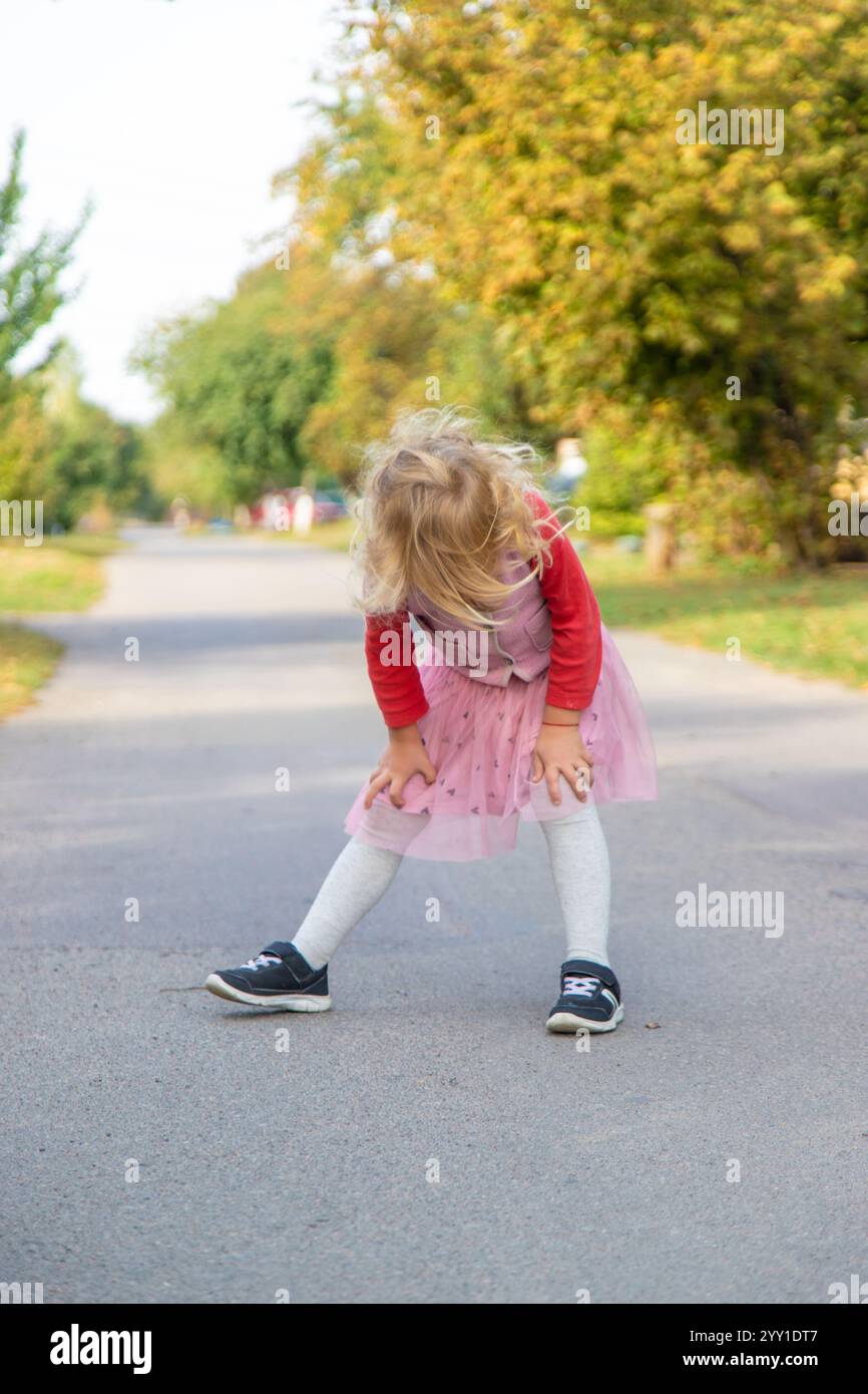 The child fell on the road and hit her leg. Selective focus. kid Stock ...