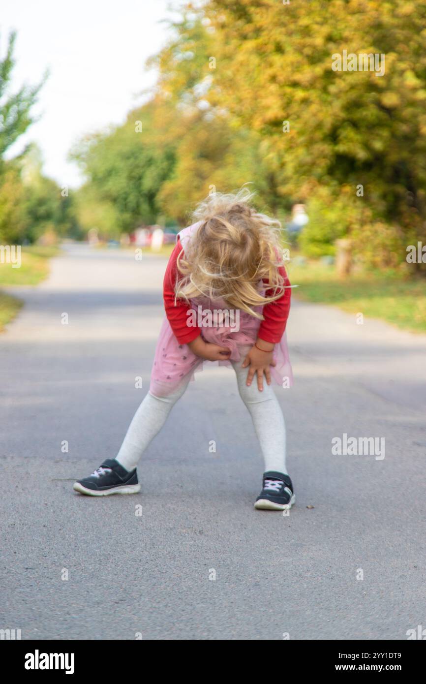 The child fell on the road and hit her leg. Selective focus Stock Photo ...