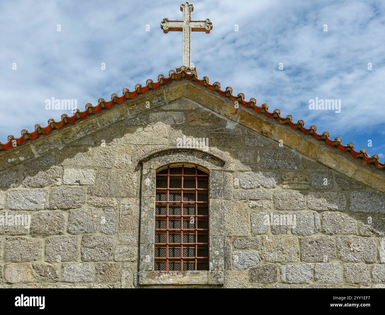 Top of a stone house with a Catholic cross in the Portuguese town of ...