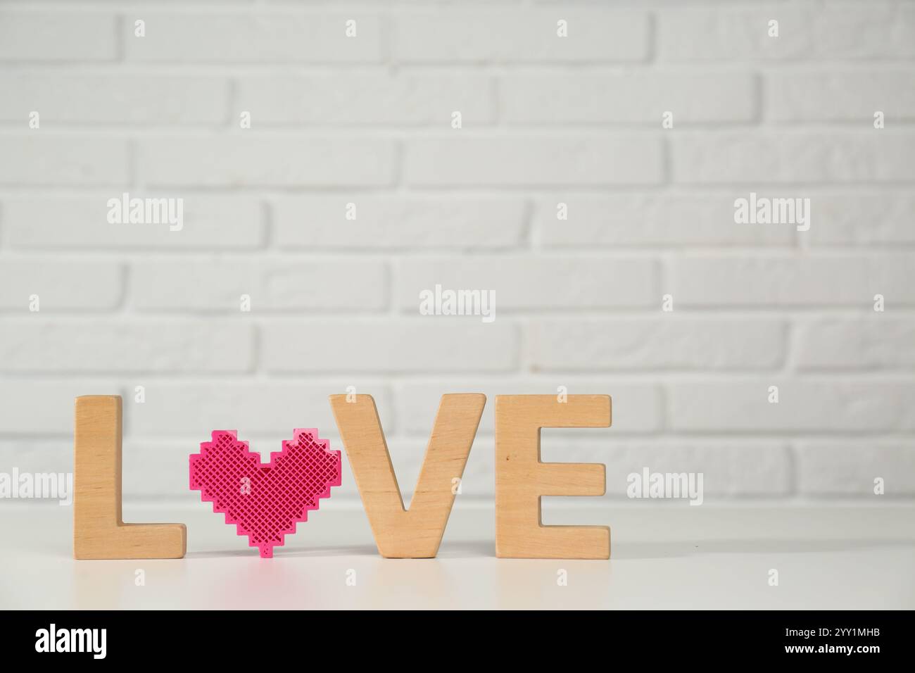 Word Love made of wooden letters and decorative heart on white table ...